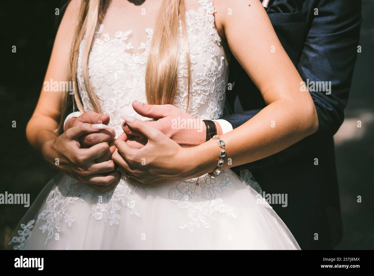 The bridegroom embraces the bride's waist Stock Photo - Alamy