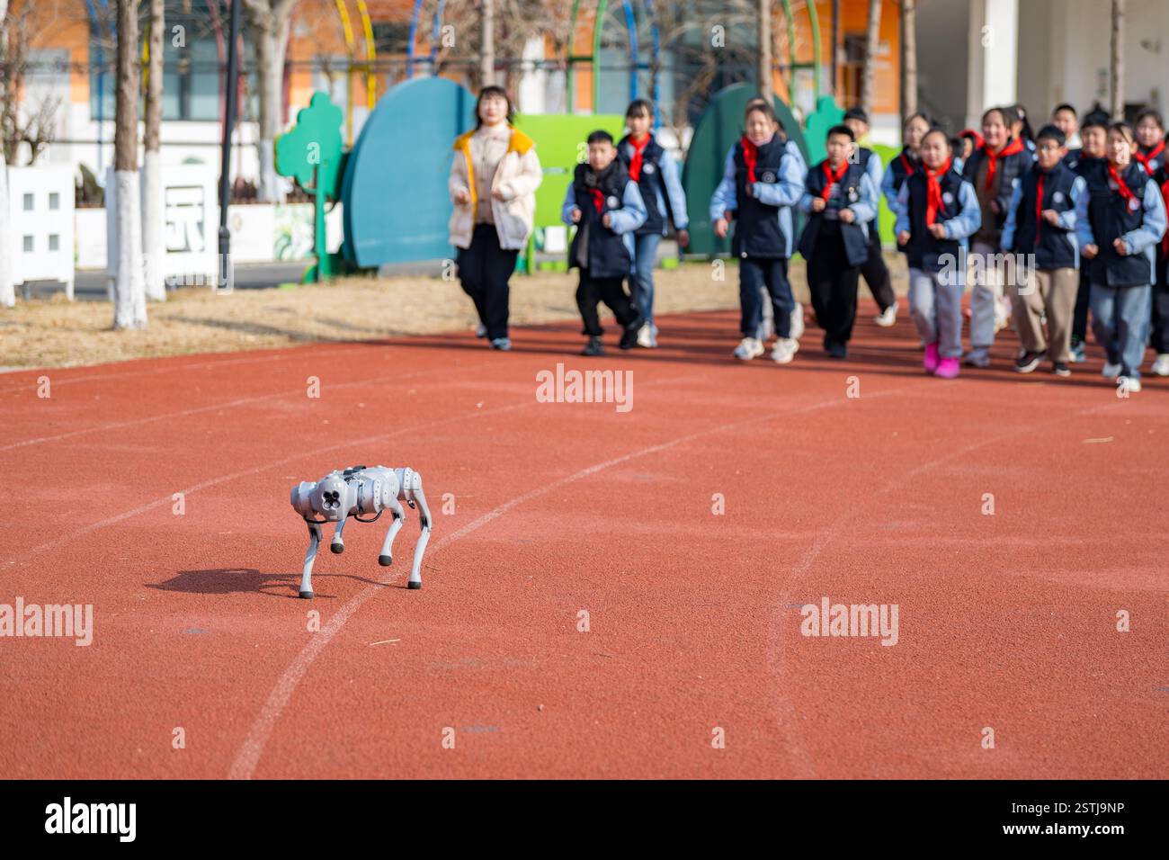 KUNSHAN, CHINA - FEBRUARY 19, 2025 - A robot dog leads students to run ...