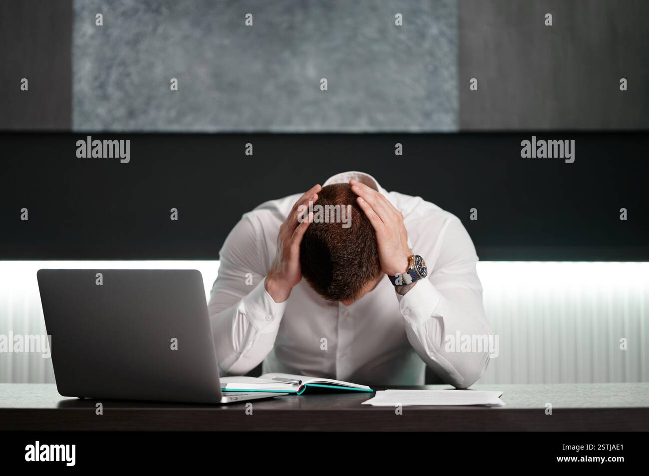 Businessman in the office sitting at his desk lowered his head and ...