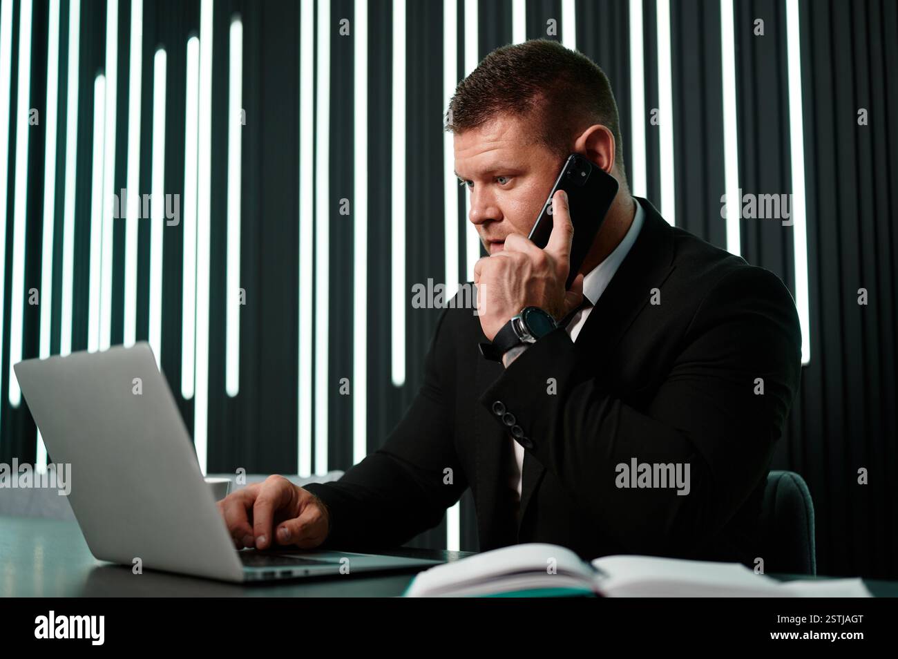 Executive businessman using his mobile phone and talking wih somebody ...