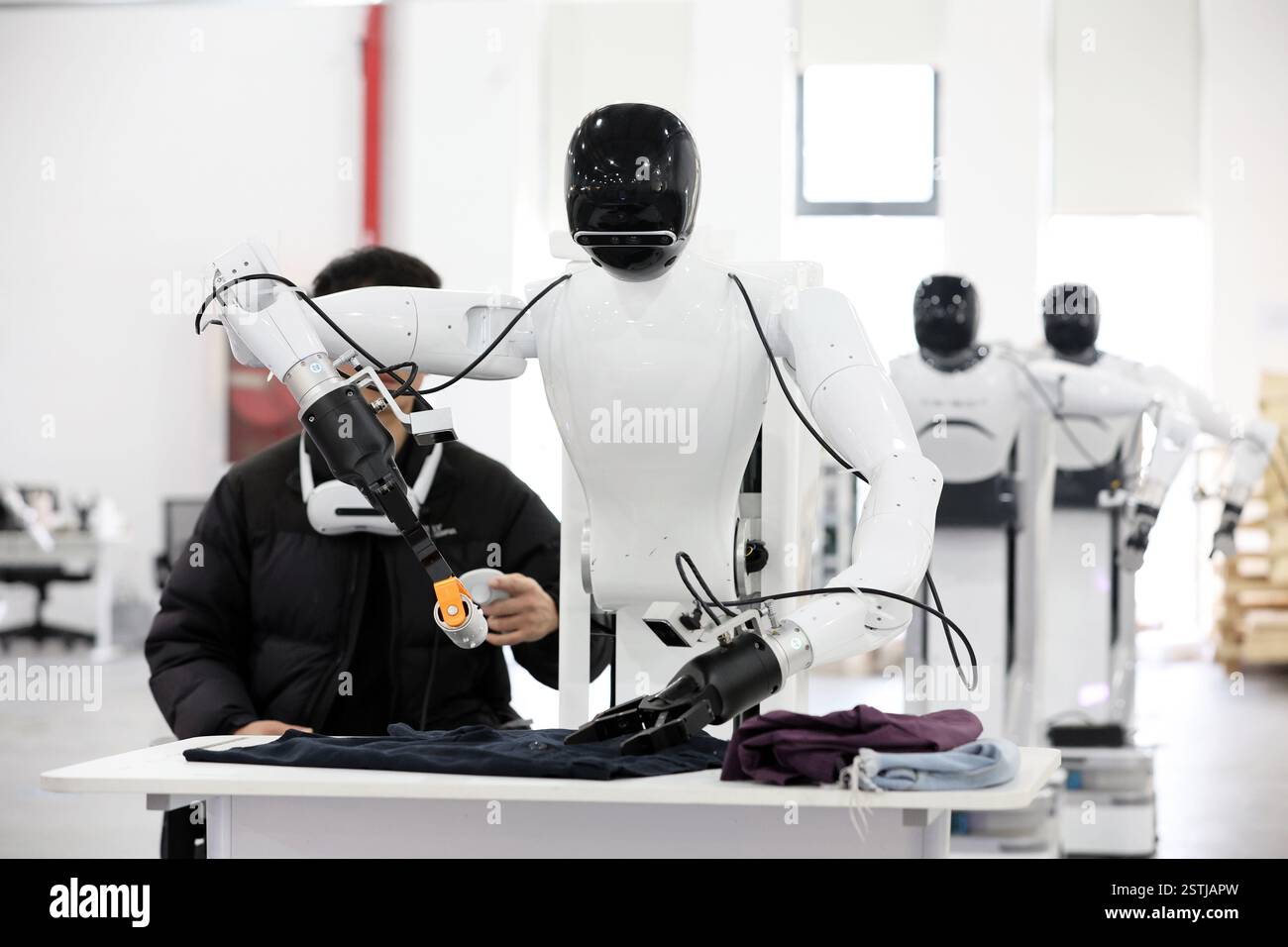 Shanghai,China.18th February 2025. An engineer trains humanoid robots ...