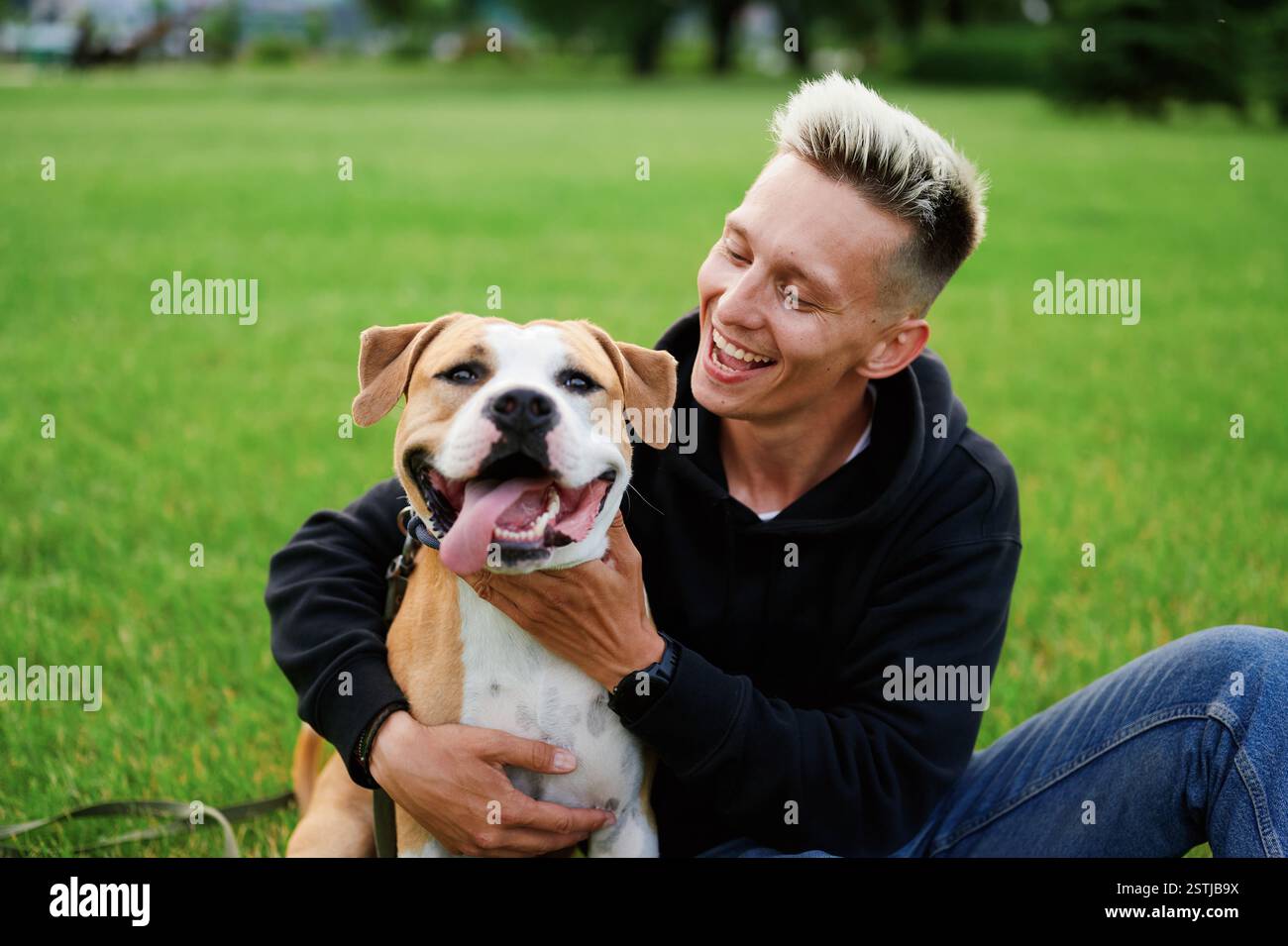 Man embracing his dog. Man hugging his dog in the field. Guy and his ...