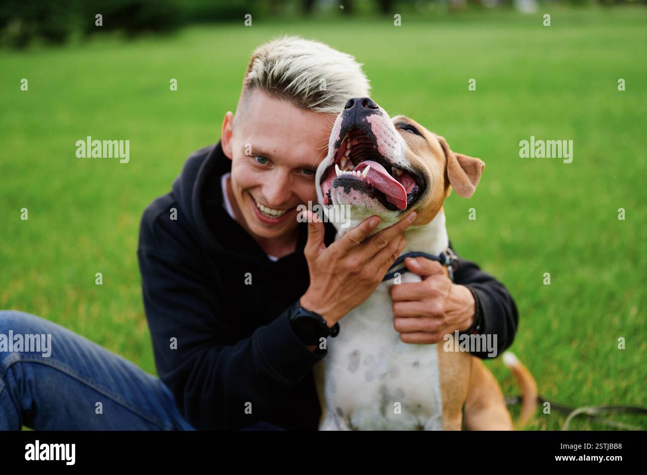 man hugging his pet dog. Happy, healthy and fit young caucasian man ...