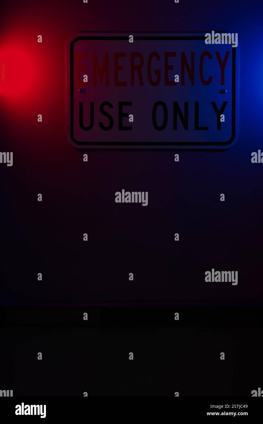 Emergency Use Only sign bathed in red and blue light Stock Photo - Alamy