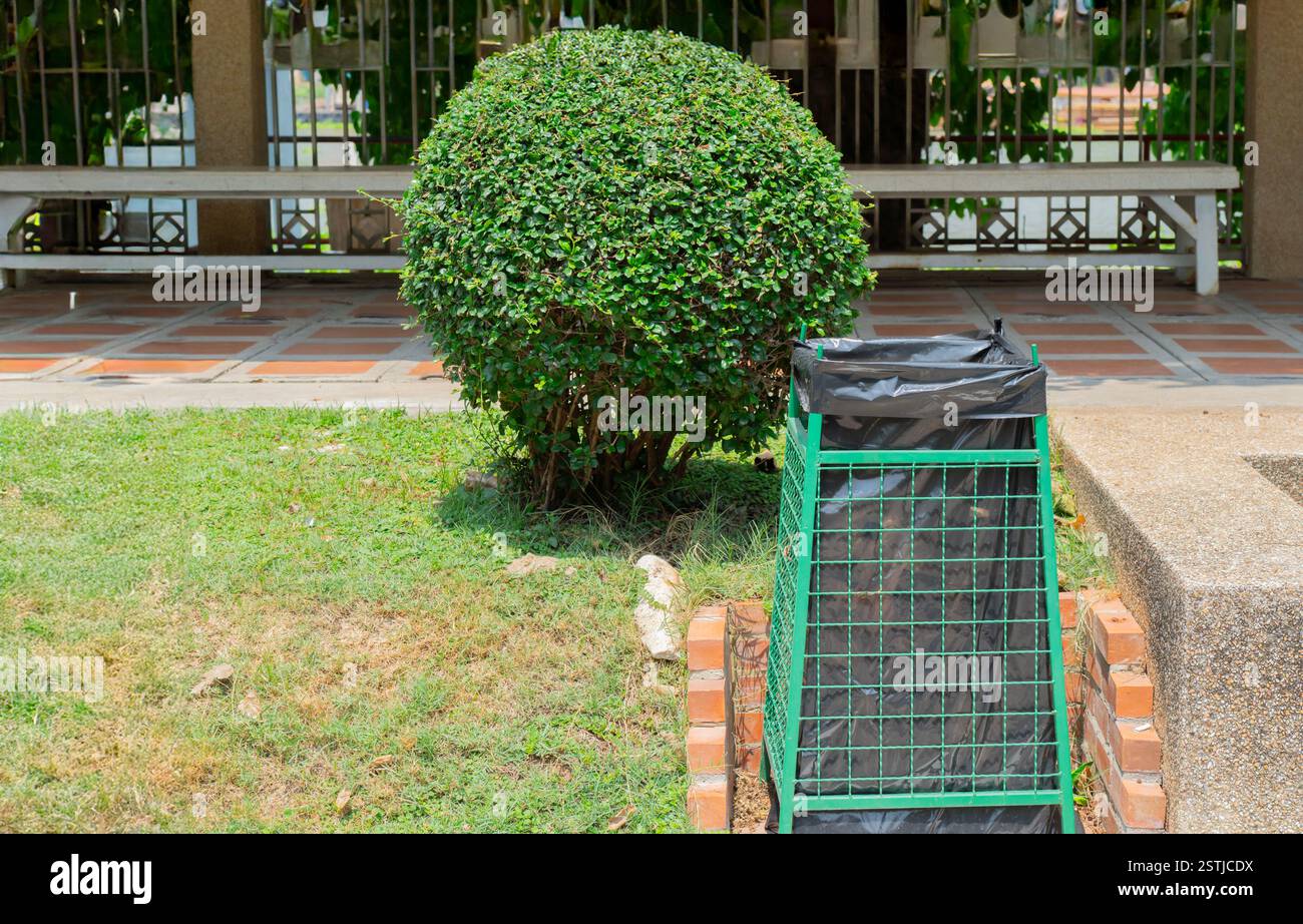 A litter bin in a park on the grass. Public rubbish bin in a park ...