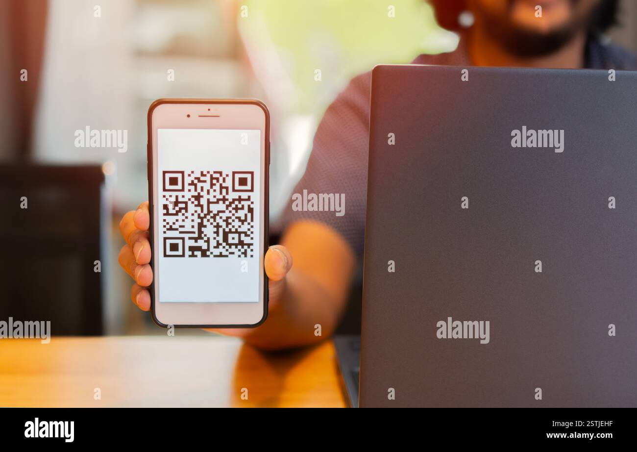 Businessman hand's holding phone with QR Code on screen, scanning for ...