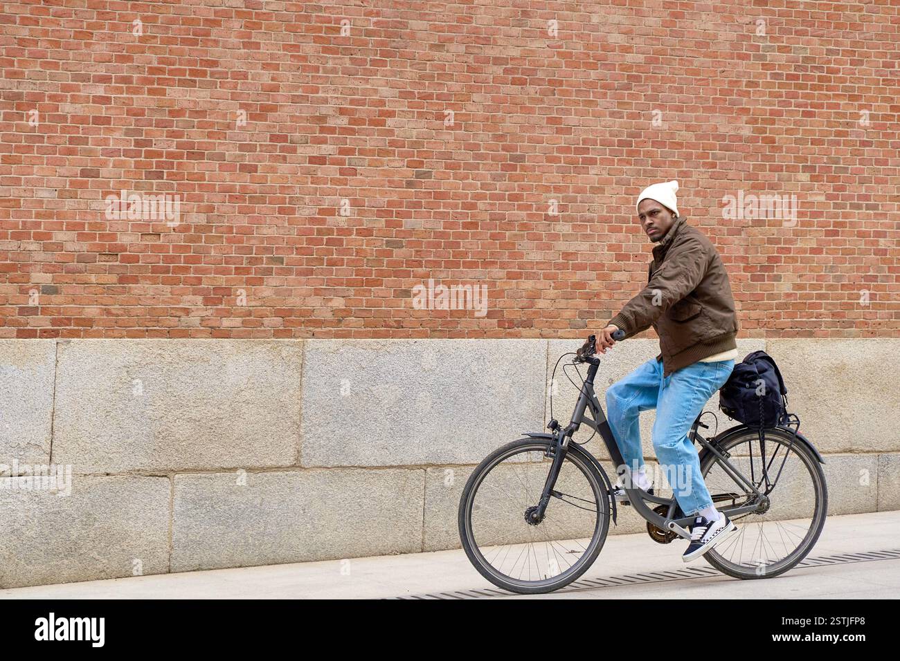 Young stylish man riding a bicycle in urban environment, sustainable ...