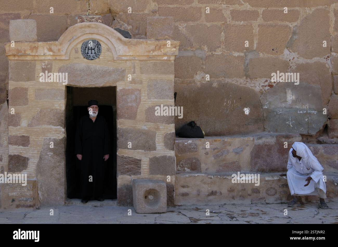 A Greek orthodox priest steps outside the back entrance to 5th century ...