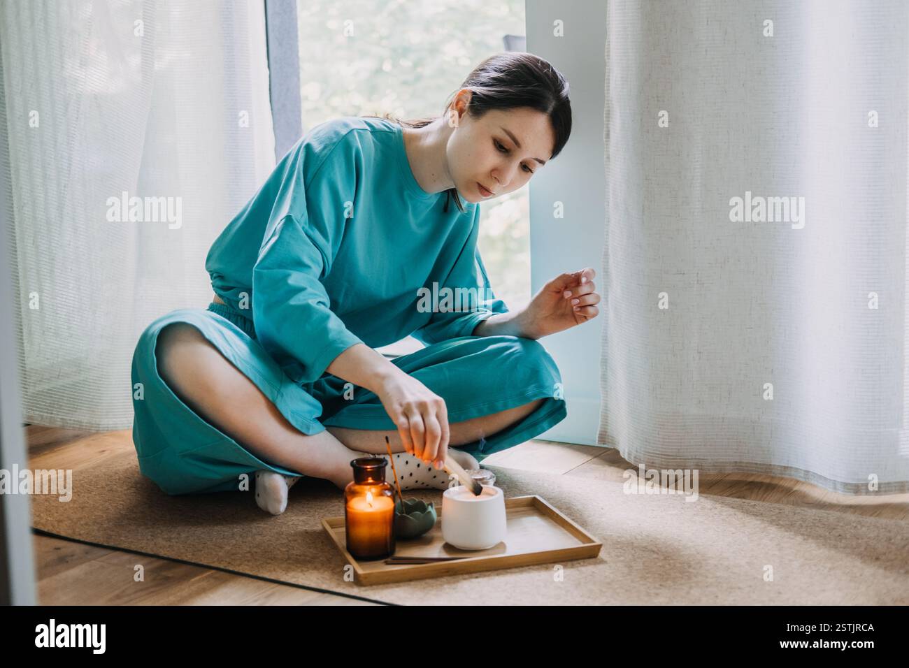 Woman setting up a wellness tray in a peaceful home corner. Creating a ...