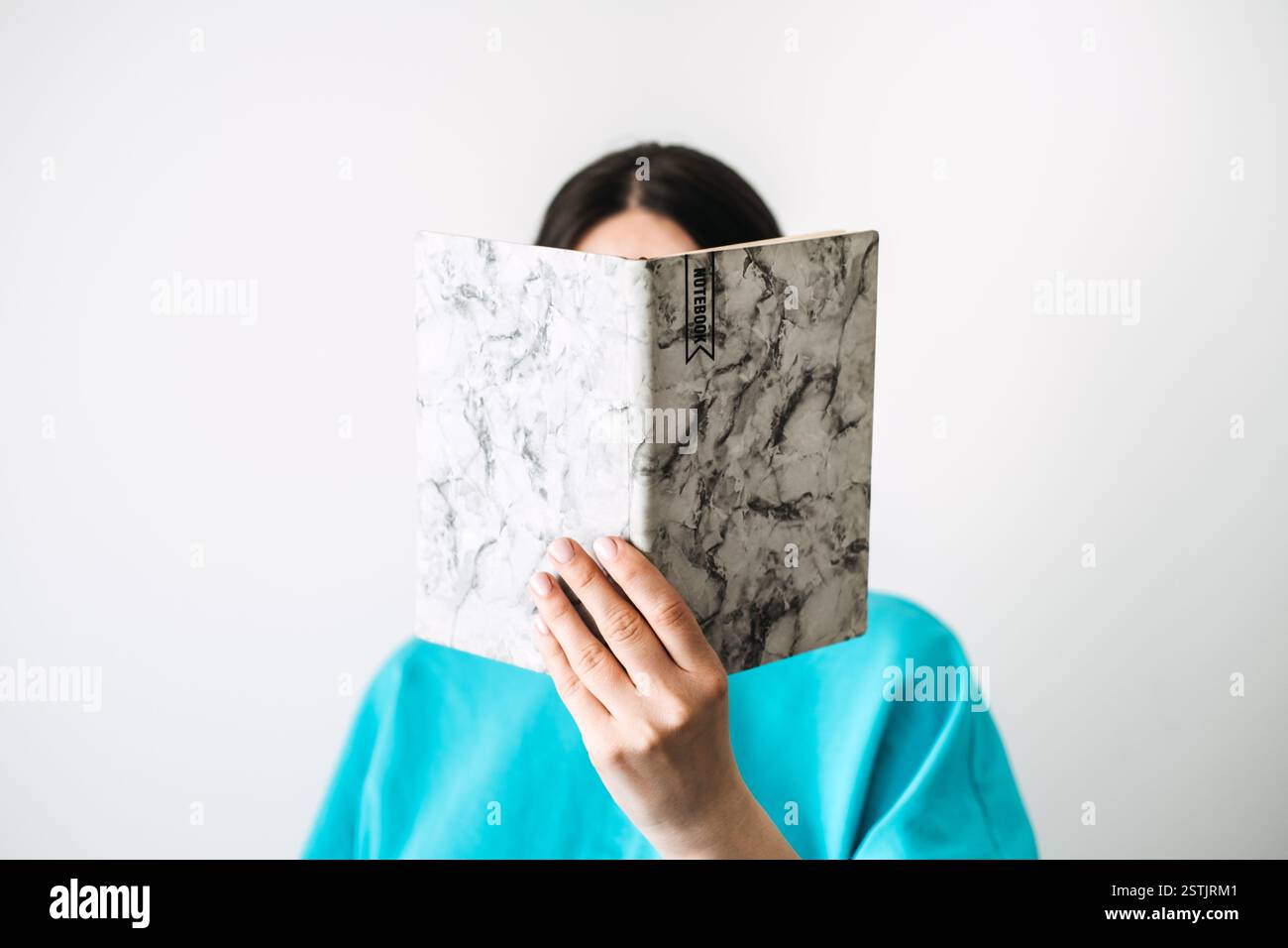 Smiling woman holding notebooks in minimalistic setting. Self ...