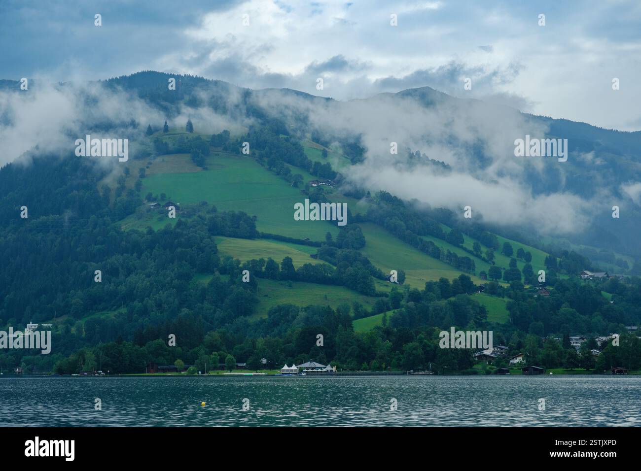 Lake Zell in the town of Zell Am See, Salzburg, Austria with lush green ...