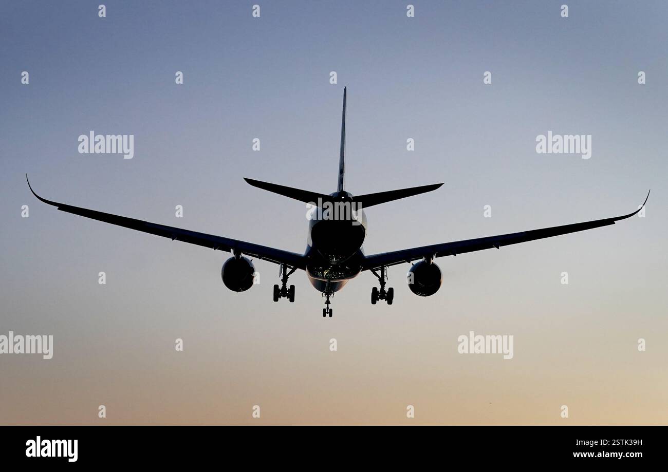 A plane lands during sunrise at London Gatwick Airport in Crawley, West ...