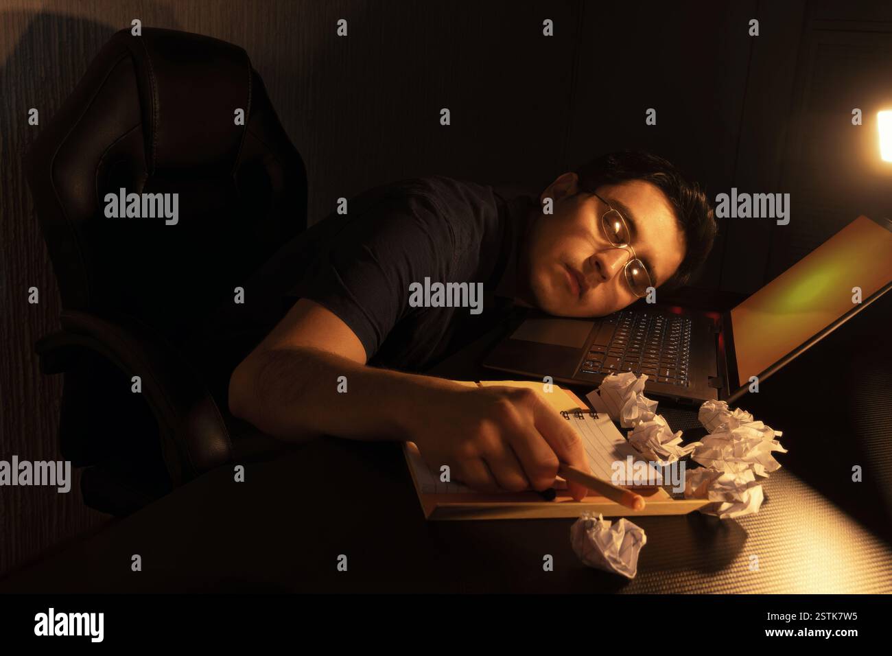 A person, seemingly overwhelmed by tasks, asleep on their desk with ...