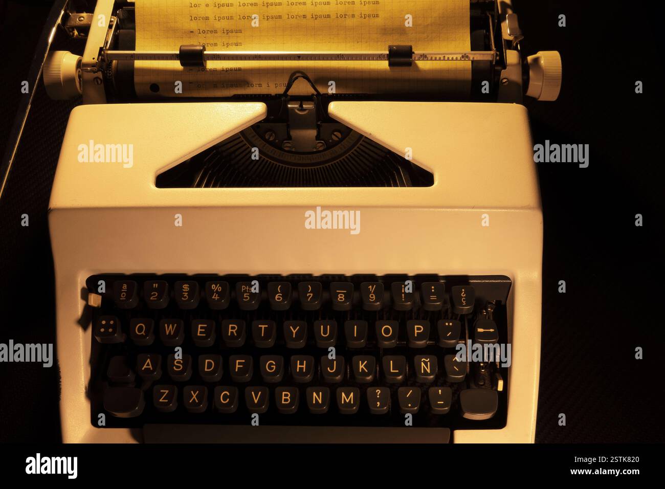 A retro typewriter bathed in golden light, its keys and aged paper ...