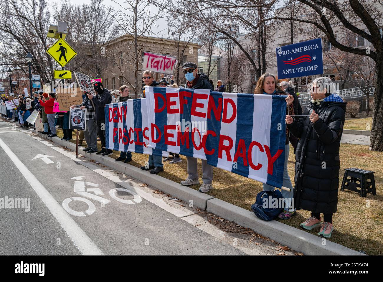 Activists hold Defend Democracy and Deny Fascism banners, and others ...