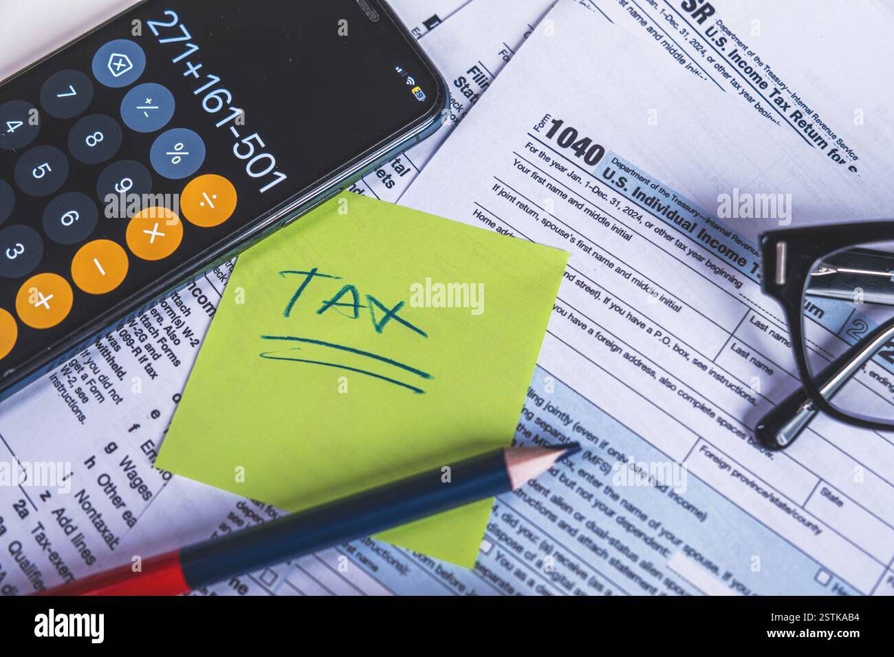 Tax form 1040, w-9, pencil, marker pen, reading glasses and laptop are ...