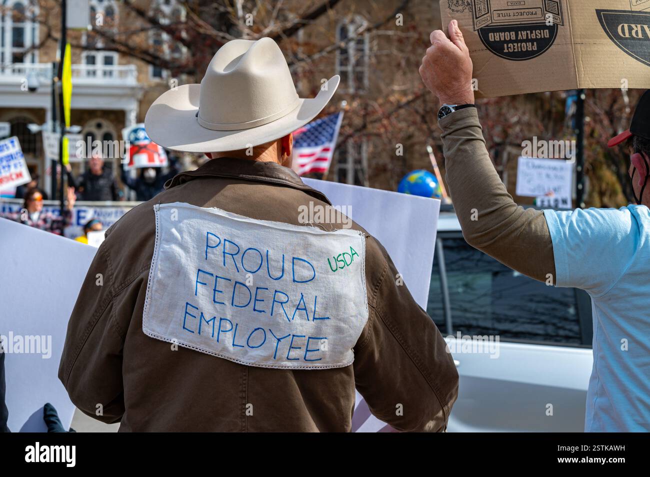 A man in a cowboy hat wearing a "Proud to be Federal Employee USDA ...