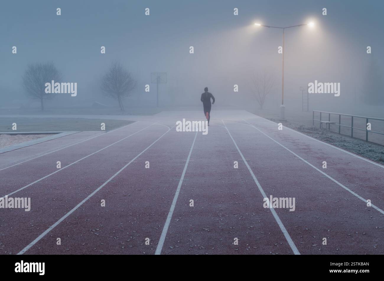 Alone Runner at frozen winter running track. Early Morning exercise in ...