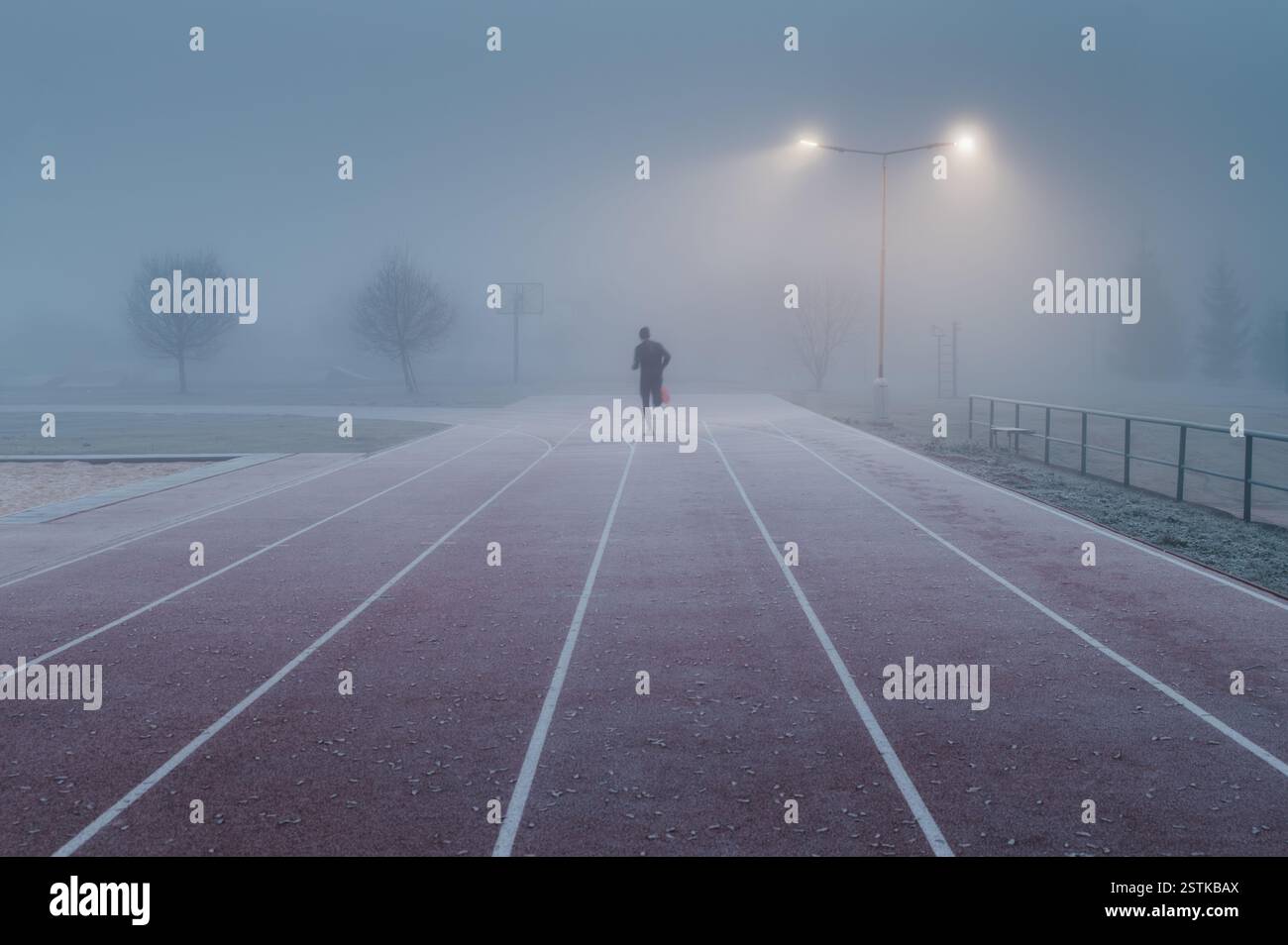 Male runner on the running track in frozen winter morning. Training ...