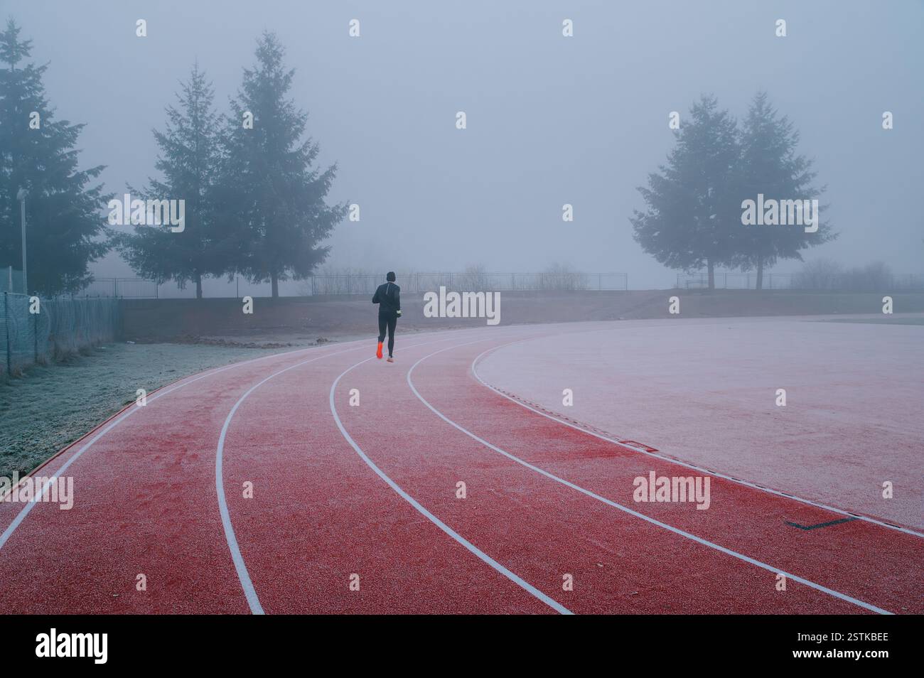 Alone Runner at frozen winter running track. Early Morning exercise in ...