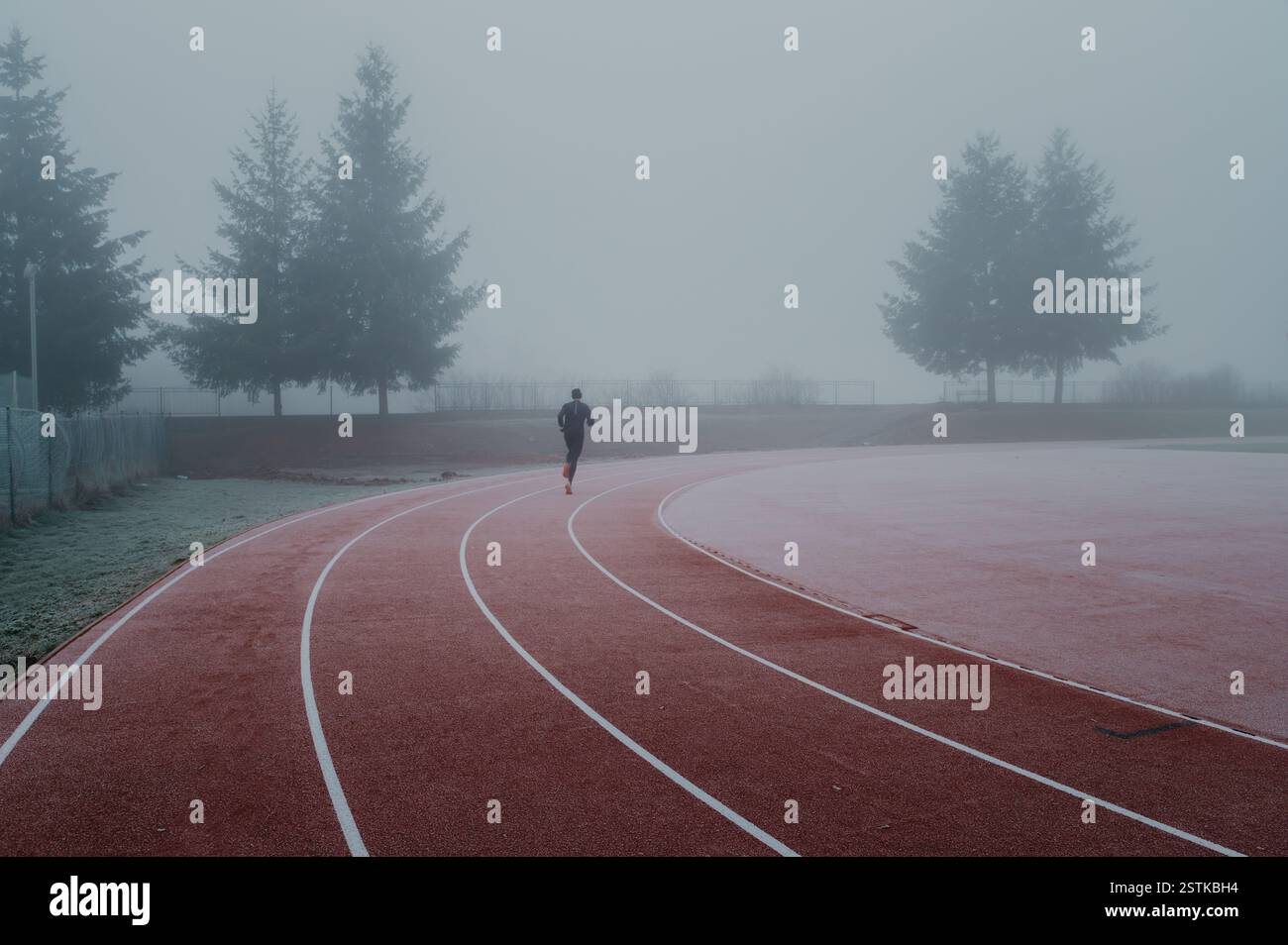 Male runner on the running track in frozen winter morning. Training ...