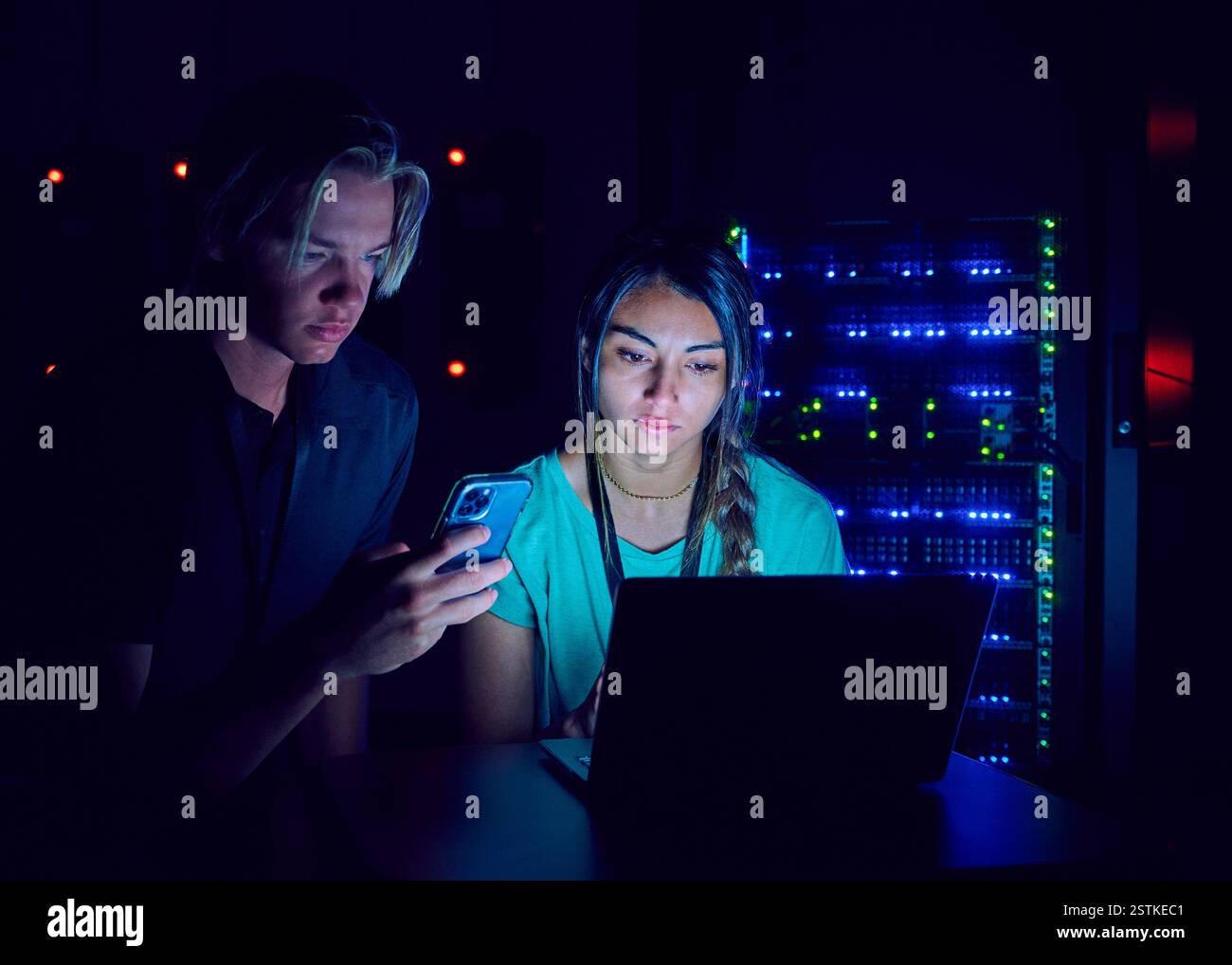 Female and male technicians using laptop in server room Stock Photo - Alamy