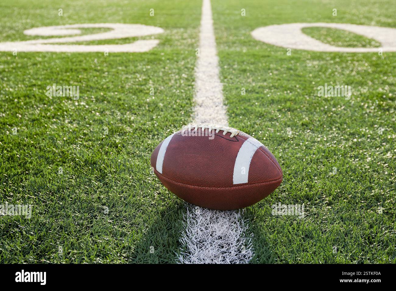 American football ball in field at 20 yard line Stock Photo - Alamy