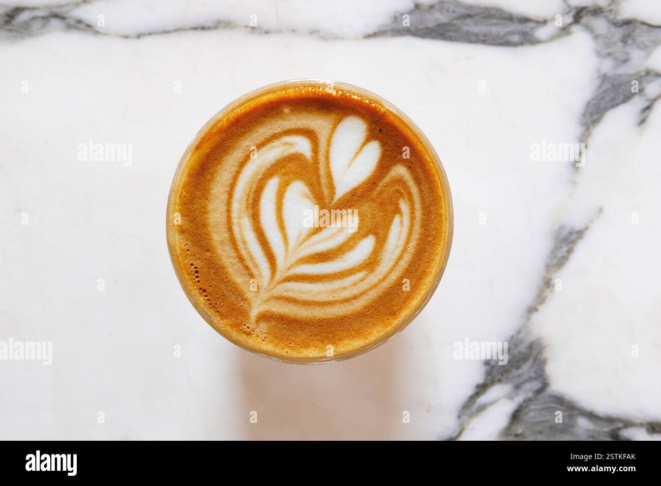 Overhead view of coffee with foam latte art on marble surface Stock ...