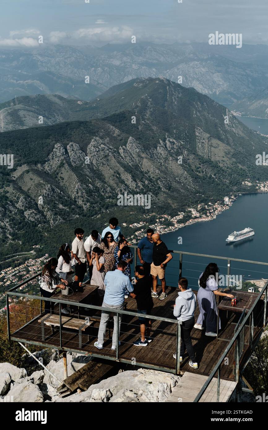 A group of tourists poses for a photo on a scenic observation deck ...