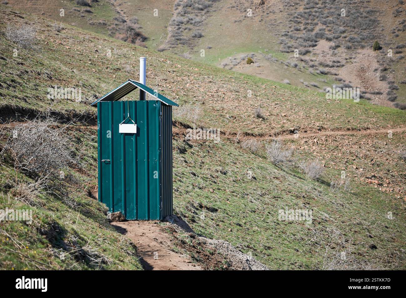Toilet cabin with a white empty sign. Countryside outdoor restroom ...