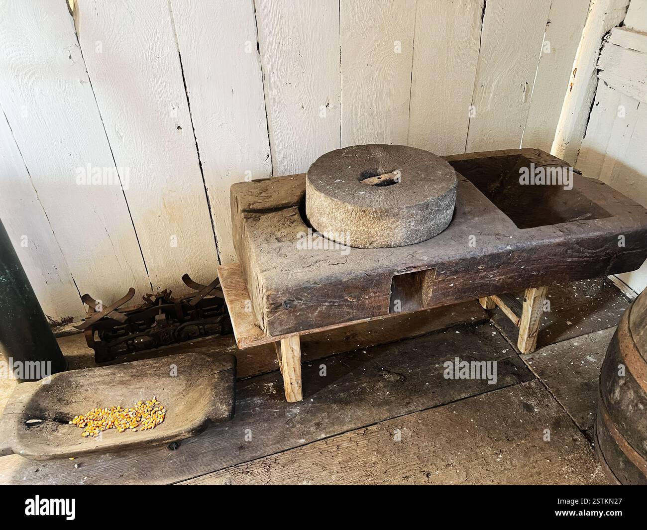 Countertop grinding stone mill with yellow corn, emphasizing rustic ...