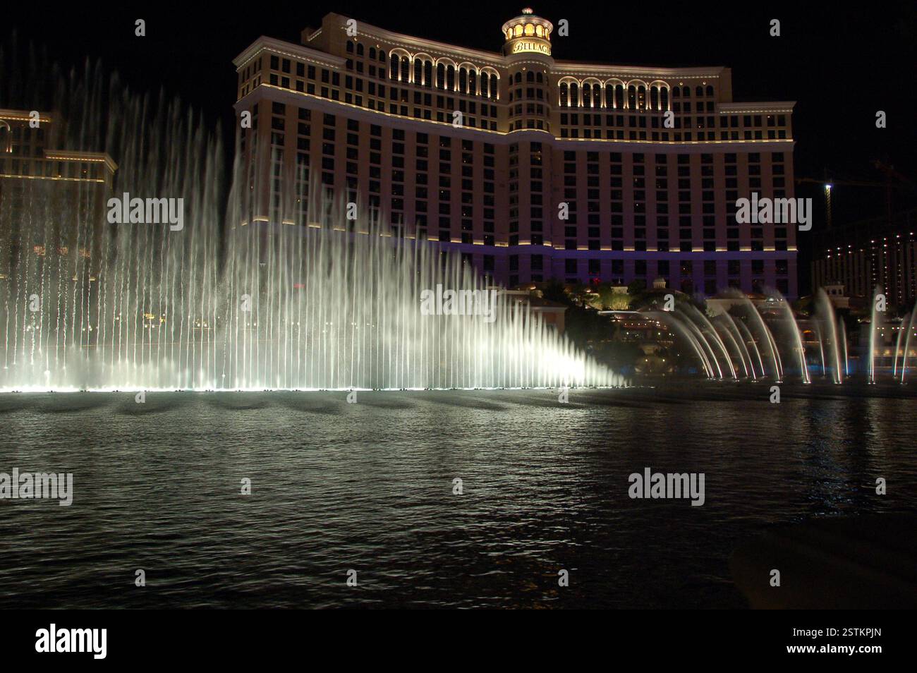 Nighttime scene at the iconic Bellagio Hotel in Las Vegas, with famous fountain show in full ...