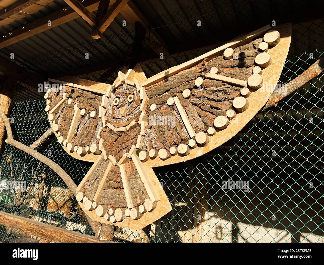Decorative wooden owl figure assembled using logs and branches against ...