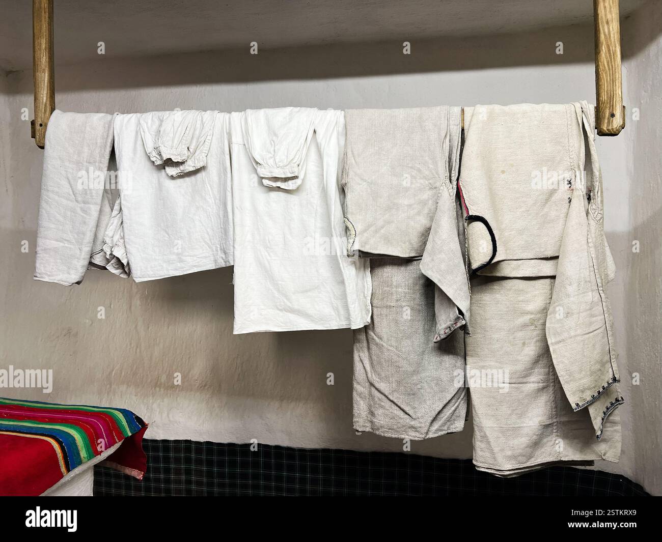 Traditional white clothing displayed on a rack in a cozy rustic home ...