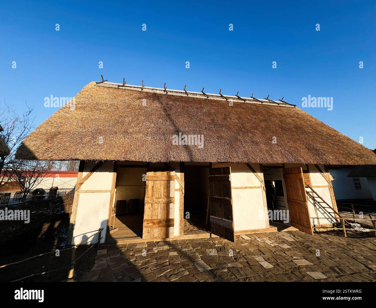 Rural ukrainian structure featuring a thatched roof and open wooden ...