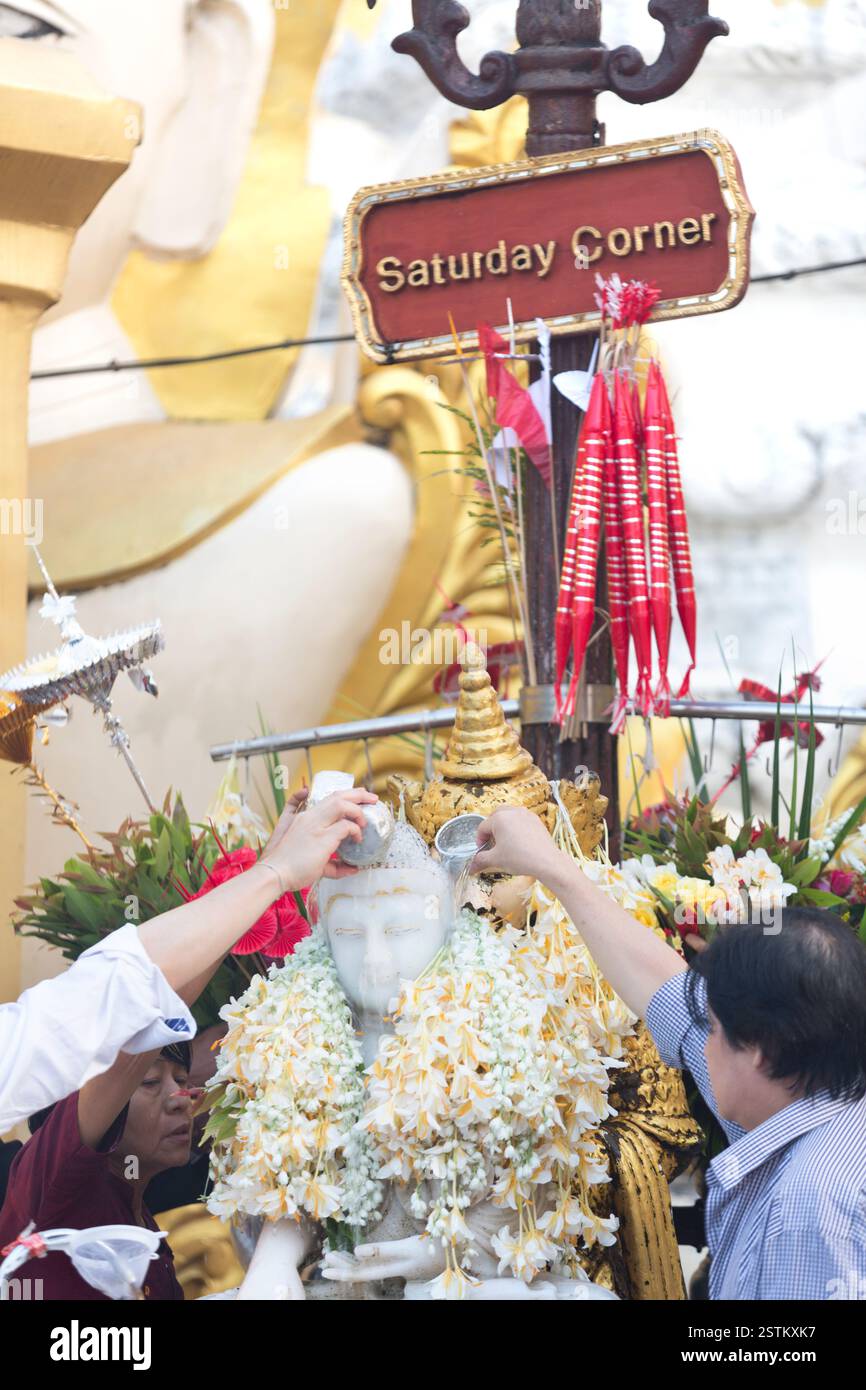 Myanmar, Yangon, pilgrims pour water over the Buddha in their birth day corner, making an ...