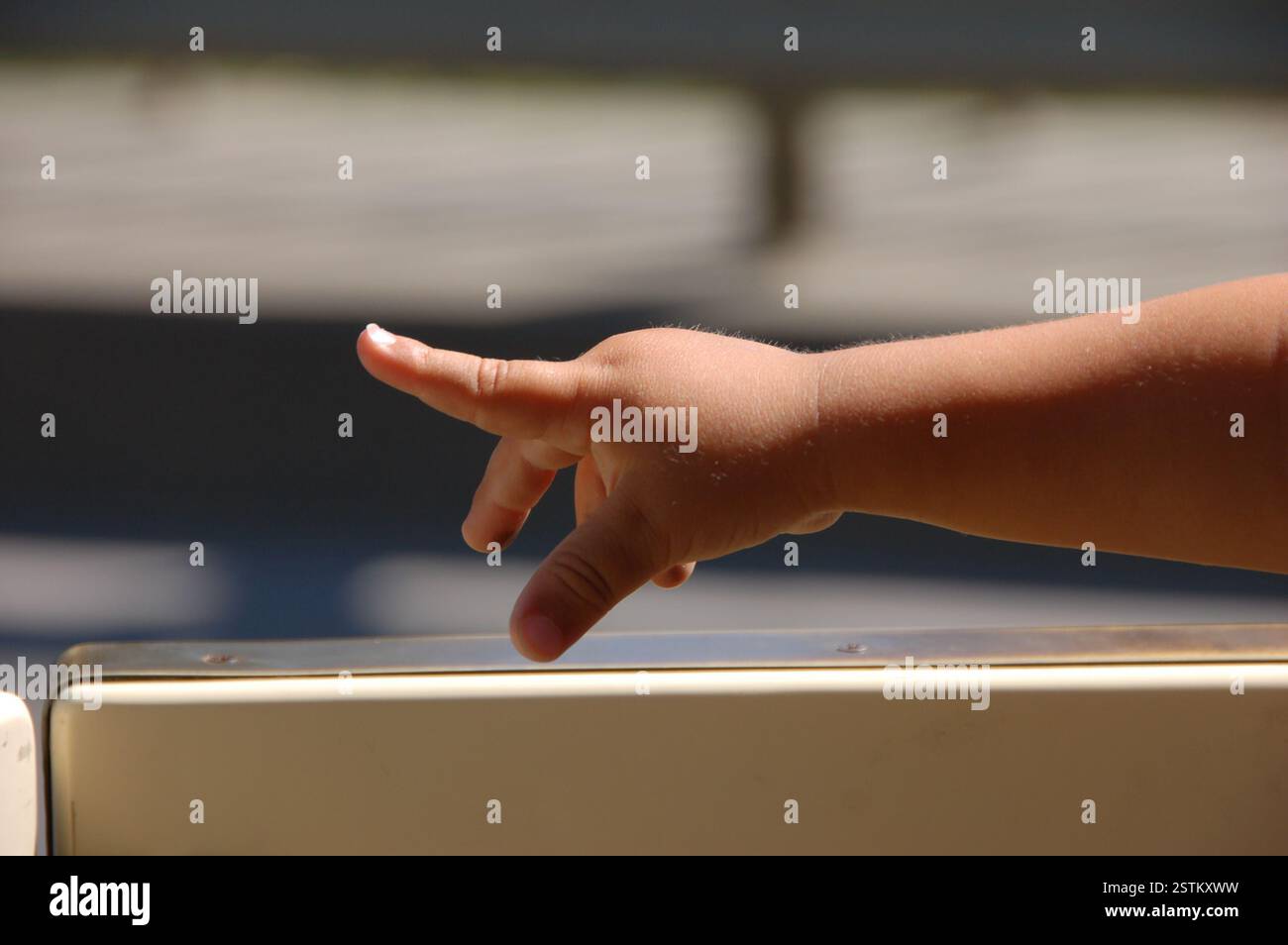 A 2-year-old child’s chubby arm, pointing forward with their index ...