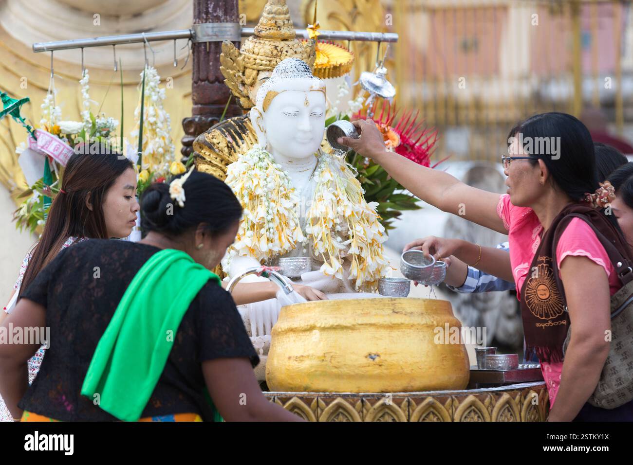 Myanmar, Yangon, pilgrims pour water over the Buddha in their birth day corner, making an ...
