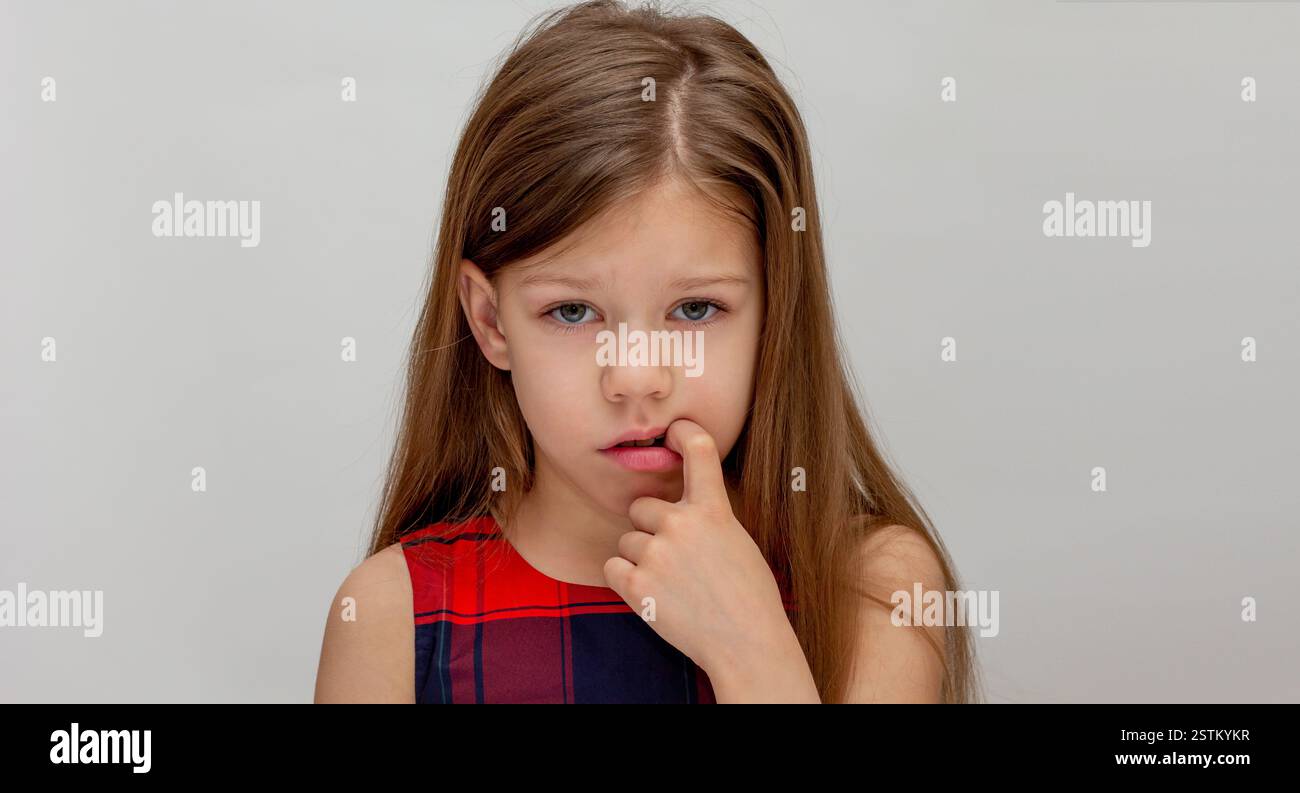 Shy child holding finger in mouth Stock Photo - Alamy