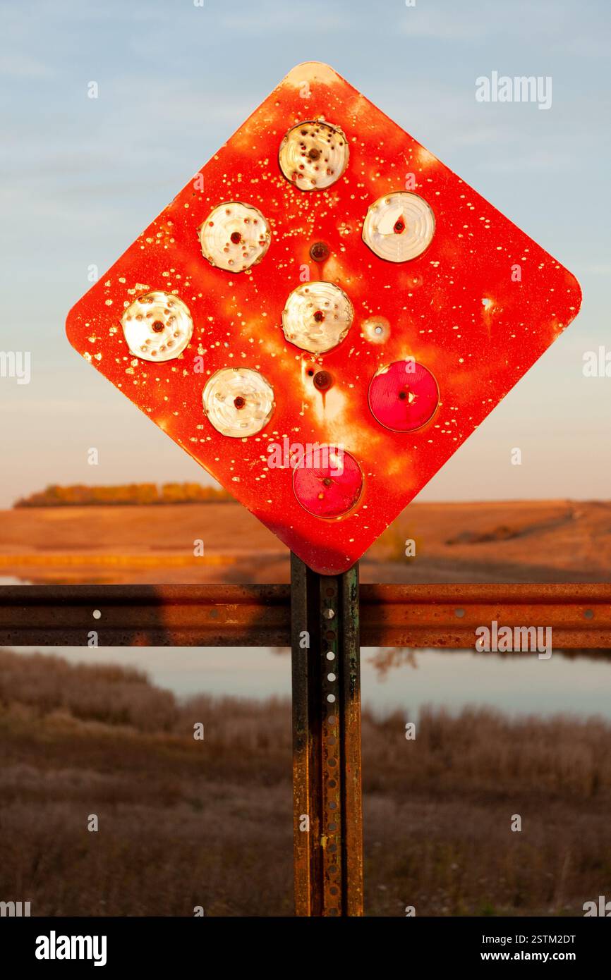 Three diamond-shaped orange and red road sign, adorned with reflectors ...