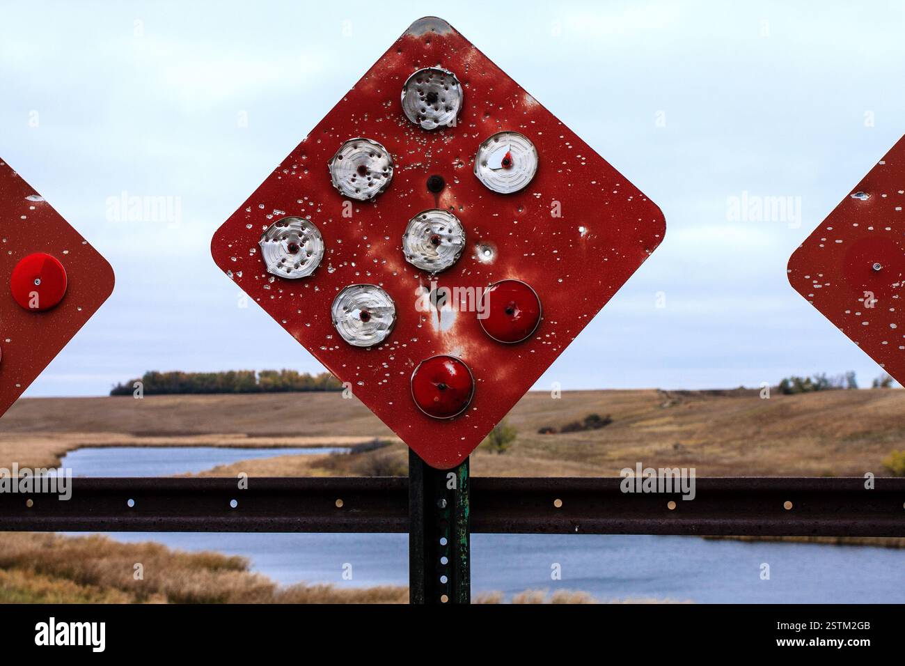 Three diamond-shaped orange and red road signs, adorned with reflectors ...