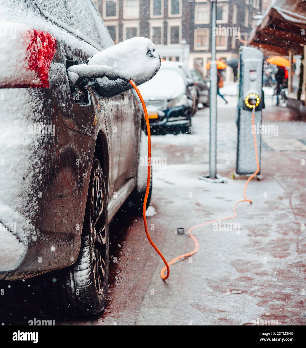 Electric car plug charging in the winter Stock Photo - Alamy