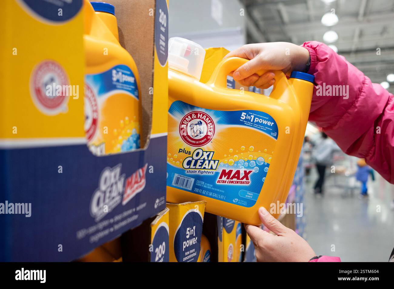A shopper grabs Arm & Hammer Oxi Clean Detergent from a grocery shelf ...