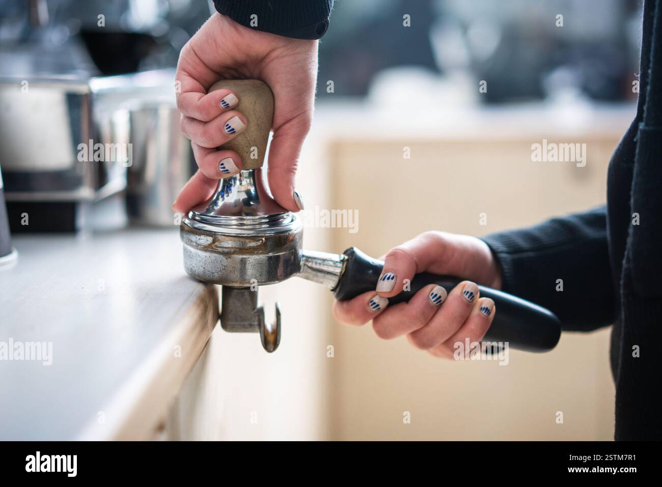 Barista presses ground coffee using tamper Stock Photo - Alamy