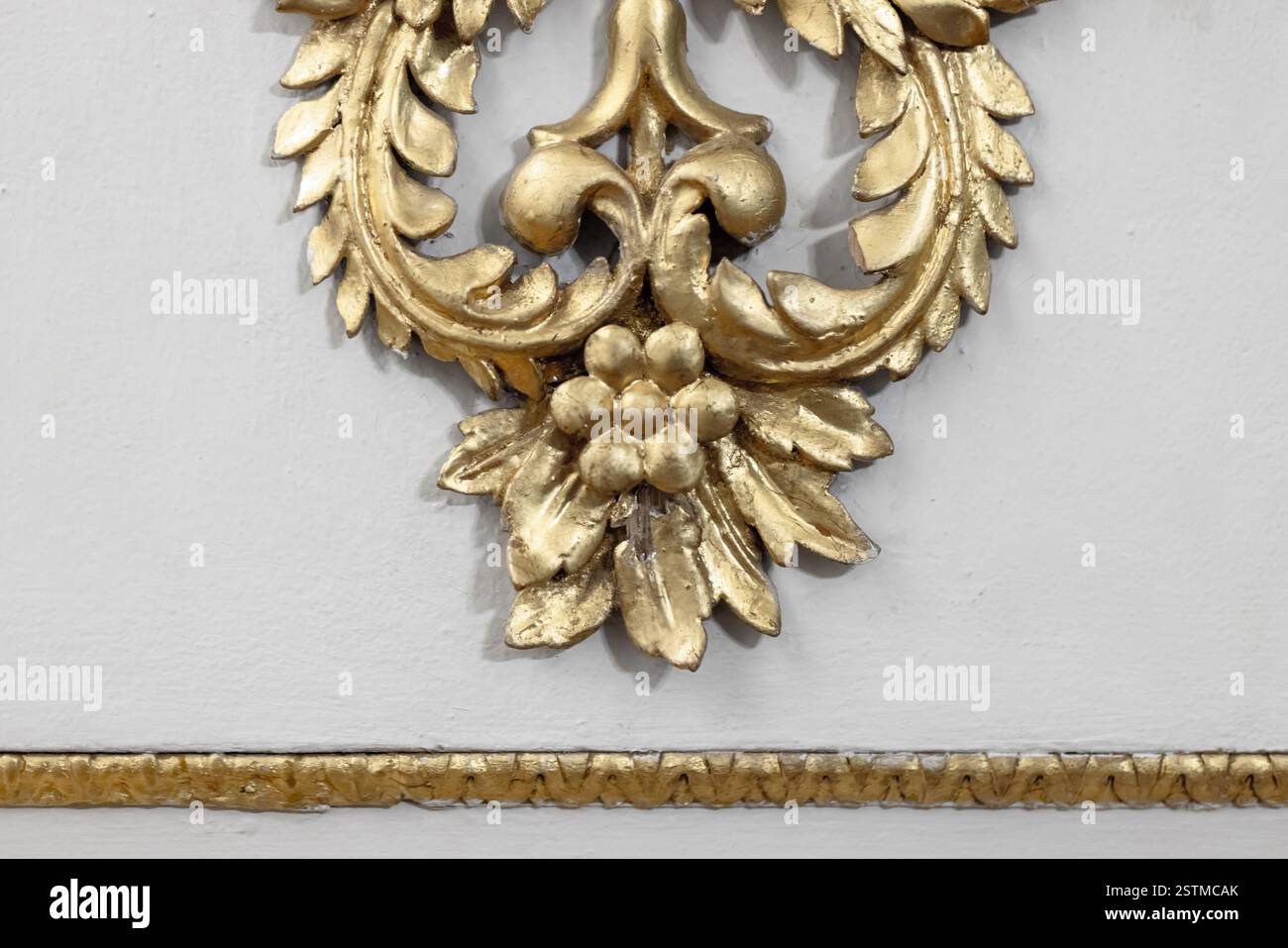Elegant gold ornamental decoration with floral motifs against a white ...