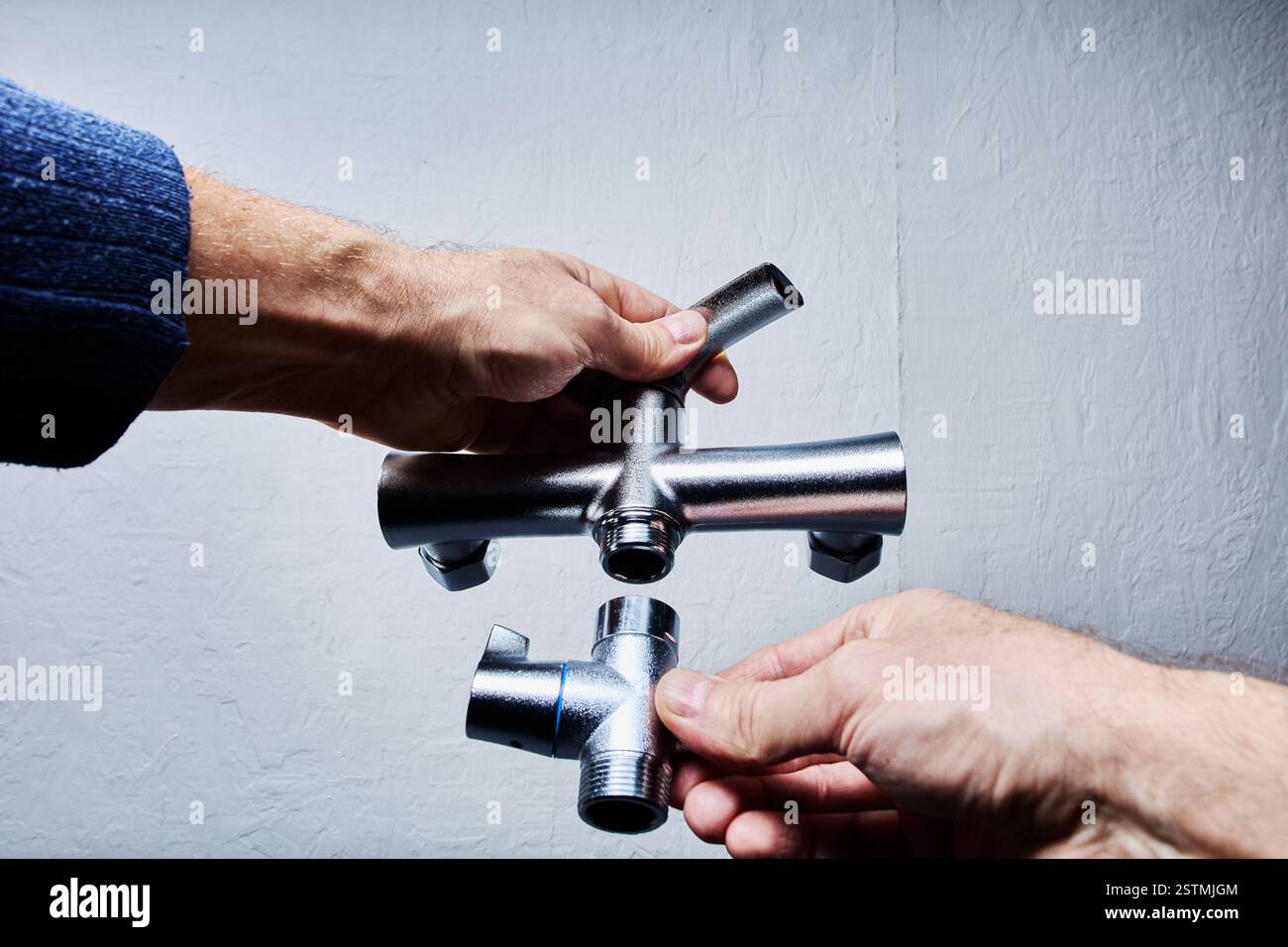 Plumber holds disassembled bathroom mixer tap, showing its main body ...