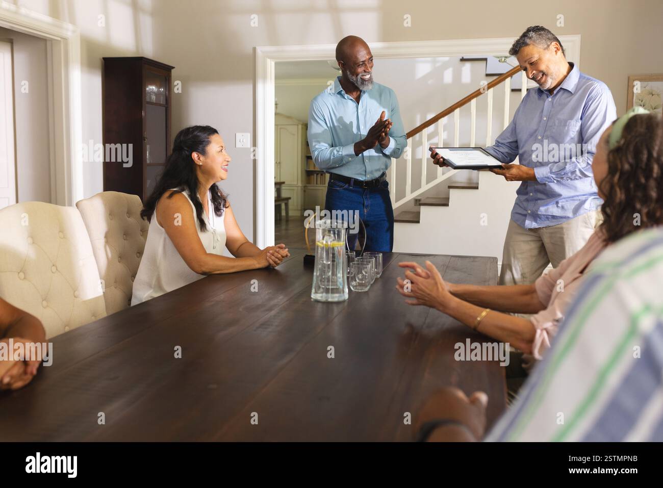 Smiling man receiving award while colleagues applaud in office meeting ...