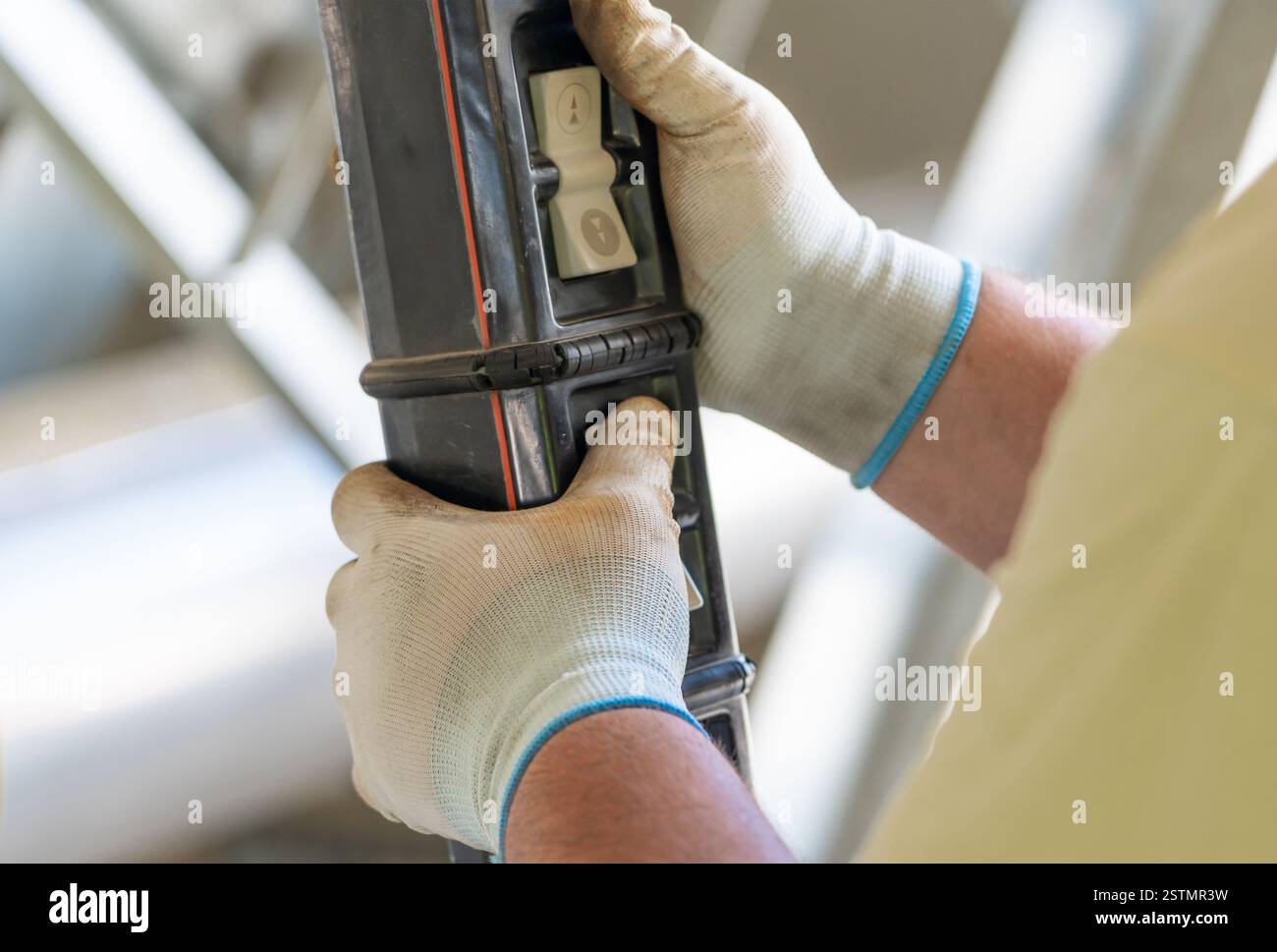 Worker operating a hoist crane control panel with protective gloves in ...