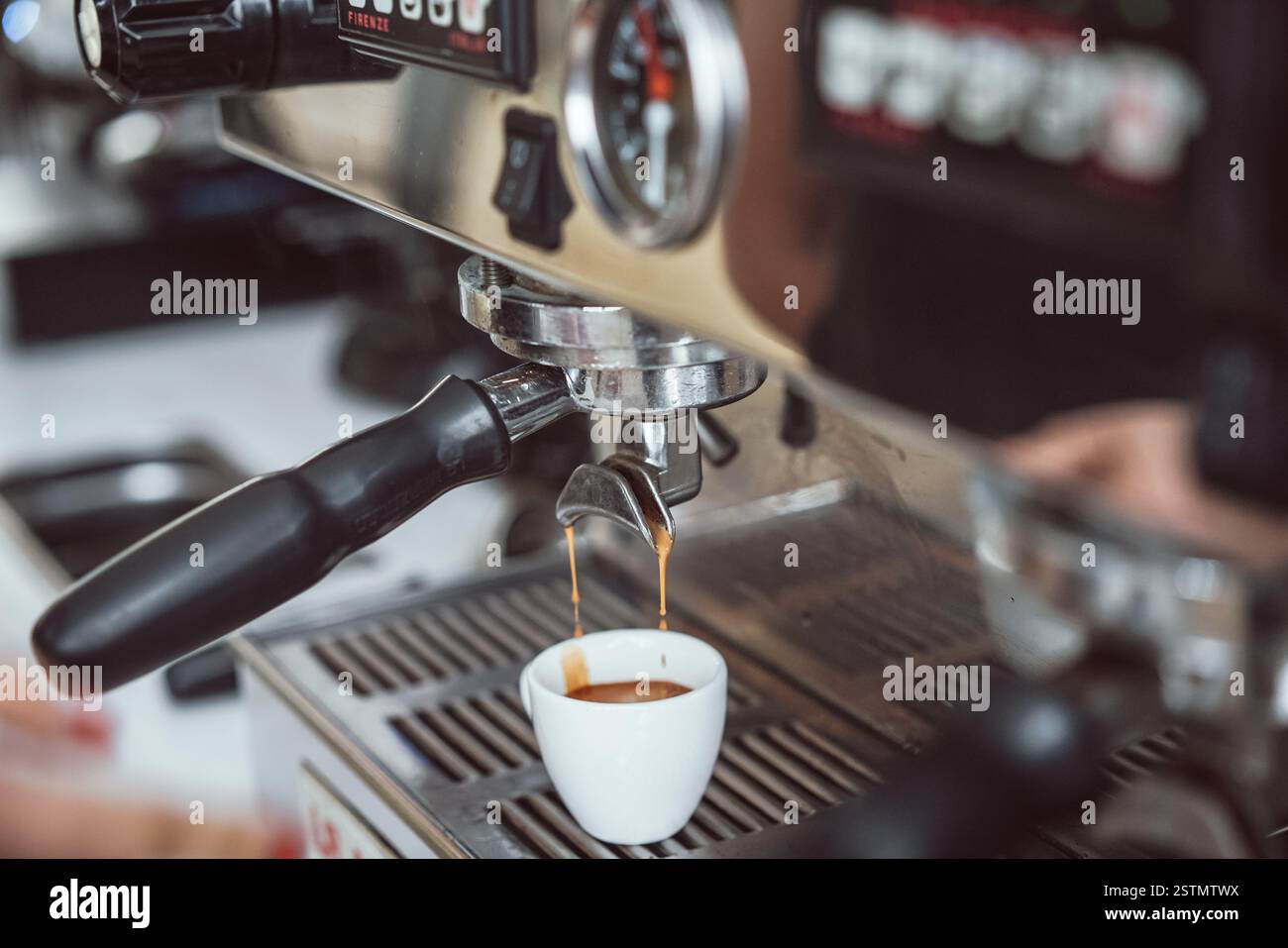 Professional espresso machine pouring fresh coffee into white ceramic ...