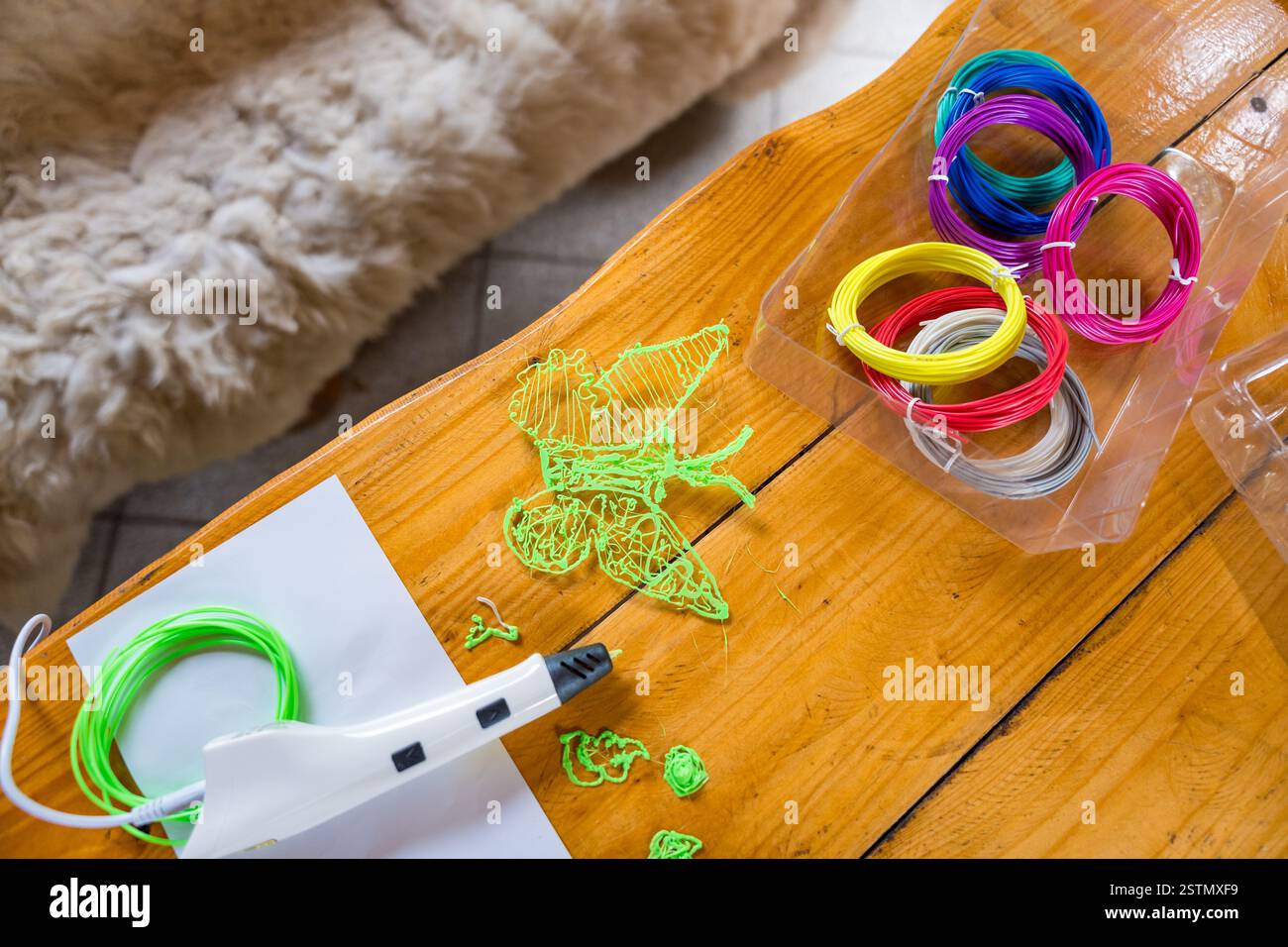 3D pen drawing with colorful filament on wooden table Stock Photo - Alamy
